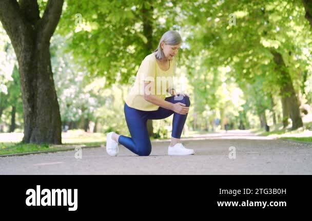 Senior runner with muscle pain. Mature old woman massaging, trauma ...