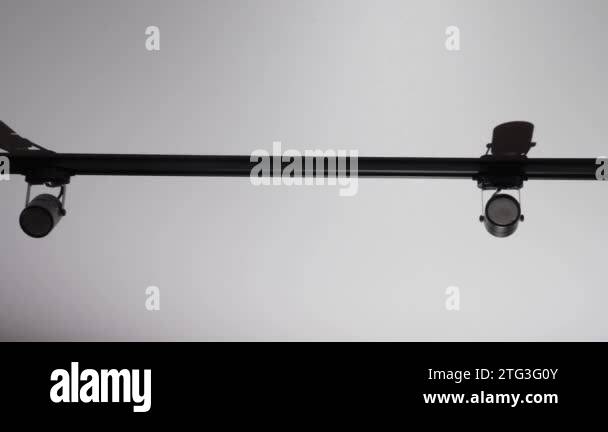 Ceiling black spotlights on a rail system on a white ceiling background ...