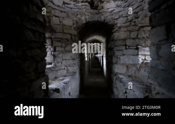 Dark corridors in an ancient castle. long stone corridor with windows ...