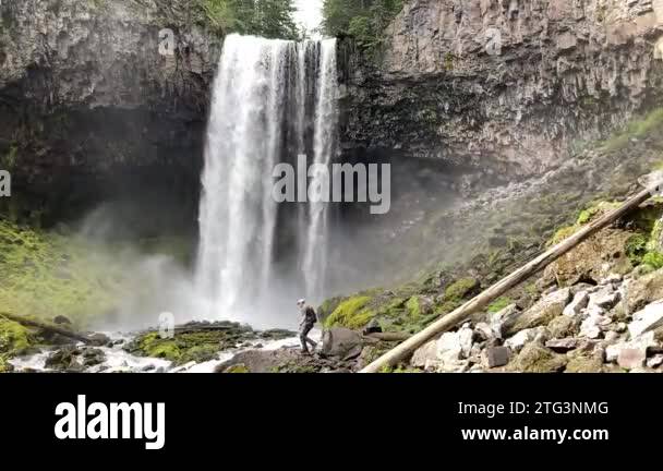 A man walks in front of the spectacular Tamanawas Falls as they tumble ...