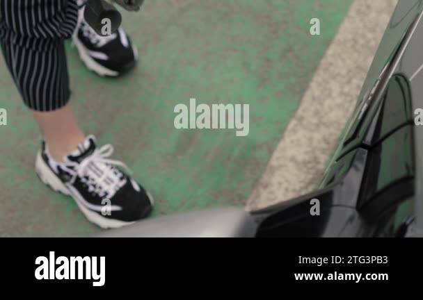 Male hand inserts power connector into EV car. Unrecognizable man ...