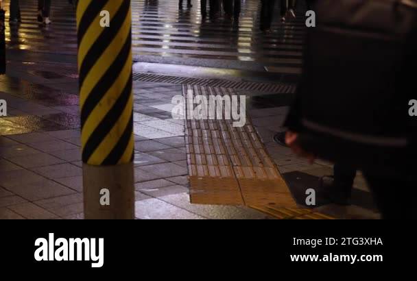 Body parts of walking people on the street in Shinjuku at night rainy ...