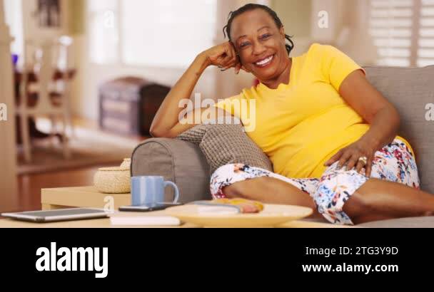 An older black woman is very happy as she poses for a portrait while ...