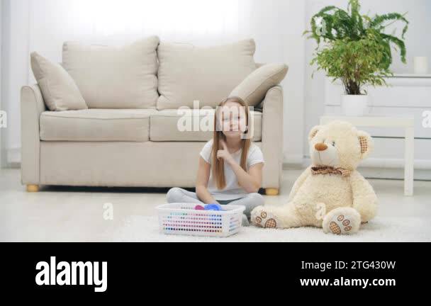 4k slow motion video of little girl sitting on the floor tidying up the ...