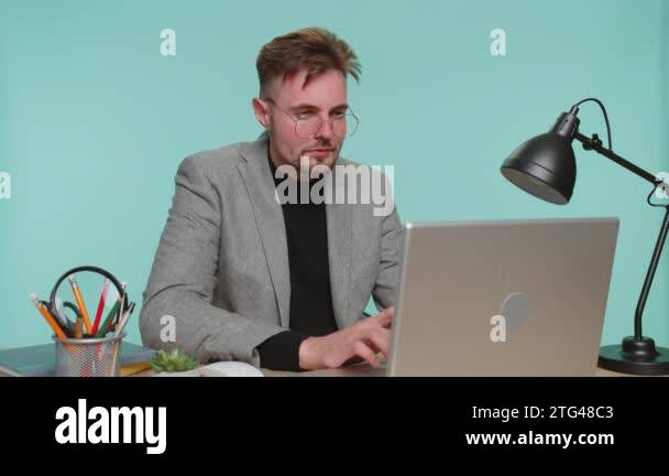 Eureka. Inspired business man sitting at office desk pointing finger up ...