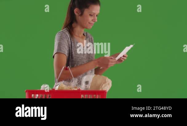 Healthy young woman grocery shopping on green screen. Pretty caucasian ...