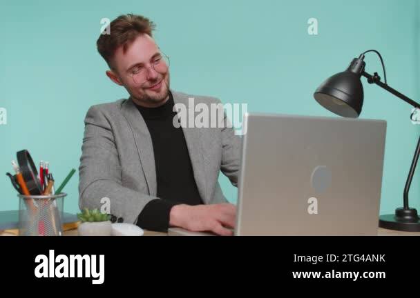 Cheerful funny bearded business man sitting at office desk showing ...