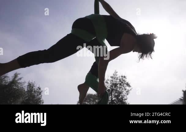 Two girls watching how their friend doing acrobatics one meter above ...