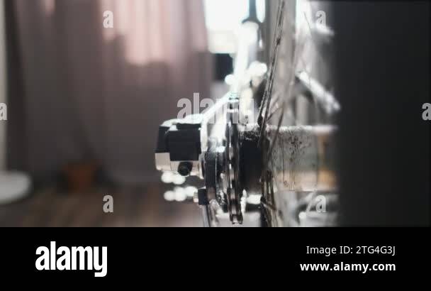 close-up of a spinning bicycle chain on a rear sprocket. The rear wheel ...
