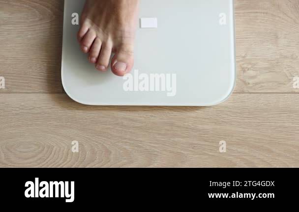 close up of Man walking on scales measure weight. male wal checking BMI ...