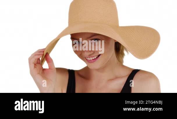 Cute Millennial girl wearing floppy sunhat and smiling at camera on ...
