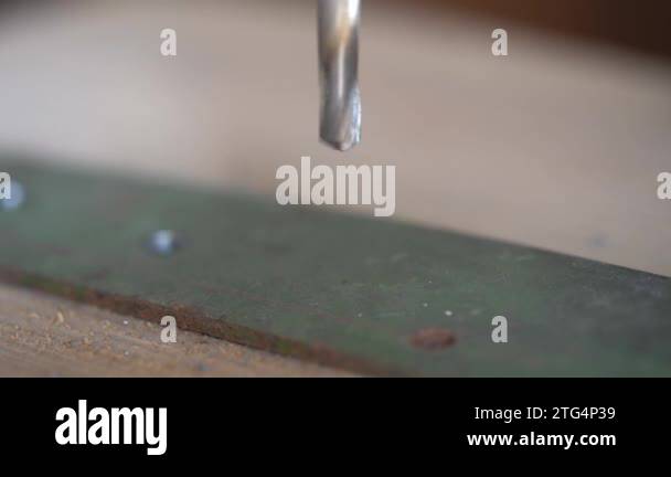 Drilling metal plate. Drill drills a sheet metal, macro. Worker drills ...
