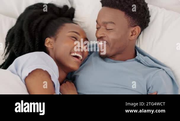 Love, smile and happy couple in bed, relax and laugh together in the morning with conversation ...