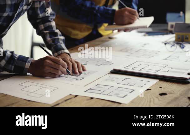Engineers and architects discuss construction plans. Work on the blueprints on the desk in the ...
