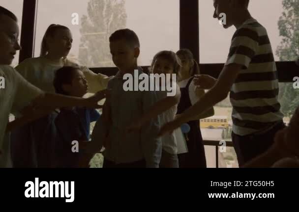 Diverse aggressive students pushing shaking conflict victim together in ...