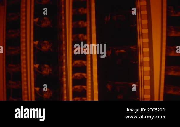 Camera movement over old film negatives in red light. Retro tape ...