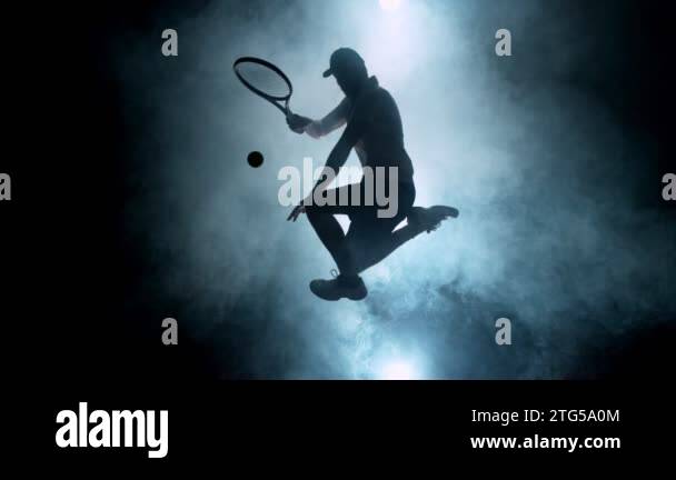 Super slow motion of tennis player silhouette hitting ball. Smoke ...