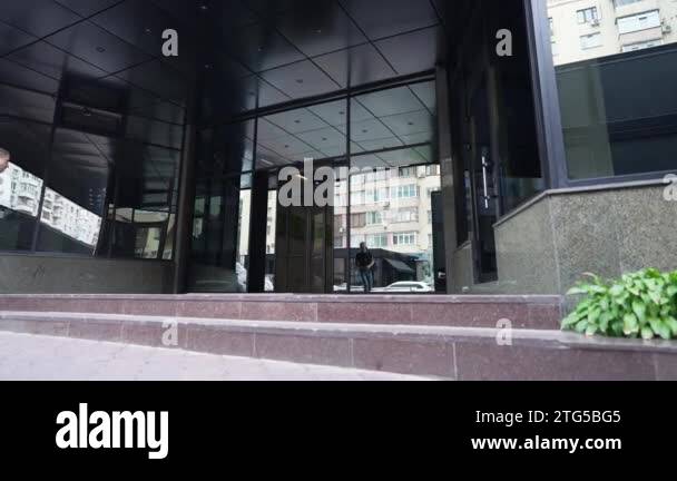 Office premises in downtown with young Caucasian man entering building ...