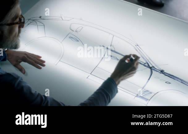 Senior automotive male designer drawing sketch blueprint with marker at ...