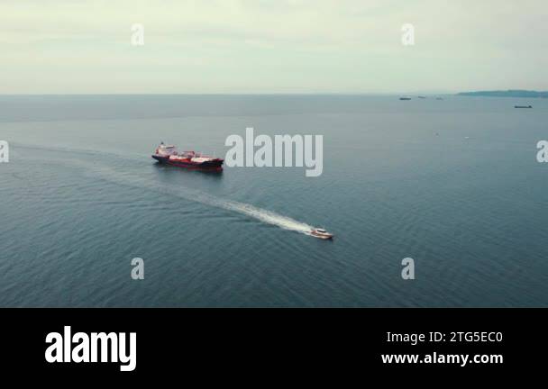 drone shot of a small ship and a tanker with liquid bulk cargo in ...