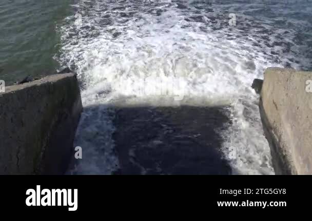 Water pollution. Dirty water from treatment plants flows through a pipe ...