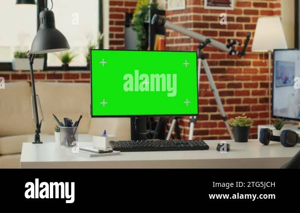 Empty work table with greenscreen template on monitor, isolated mockup background running on ...