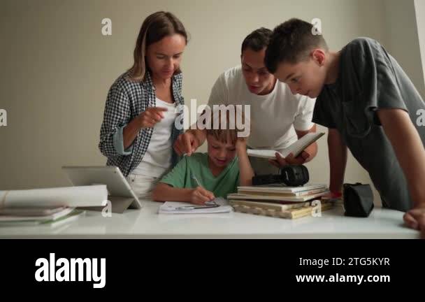 Father helping his son with schoolwork. Young little shoolboy solving mathematics homework with ...