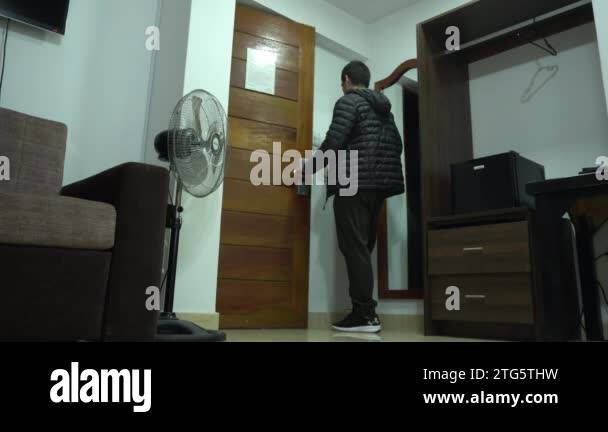 a man taking off his jacket entering a hotel room at night in 4k Stock ...