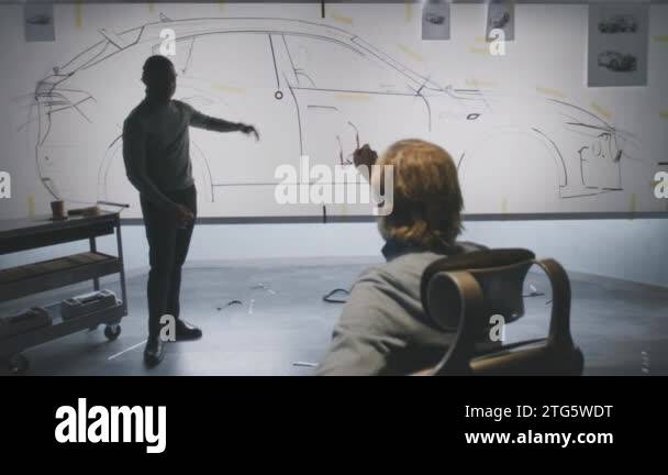 Two diverse automotive male designers discussing sketch blueprint ...