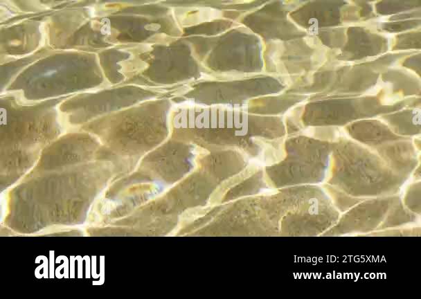 Slow motion of sun rays reflecting from clear water surface. Background ...