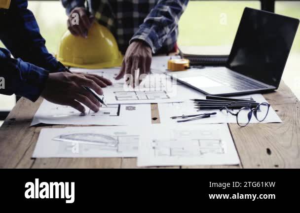 Engineers and architects discuss construction plans. Work on the blueprints on the desk in the ...