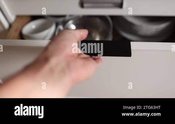 close the drawer in the kitchen. modern kitchen cabinet, man close ...