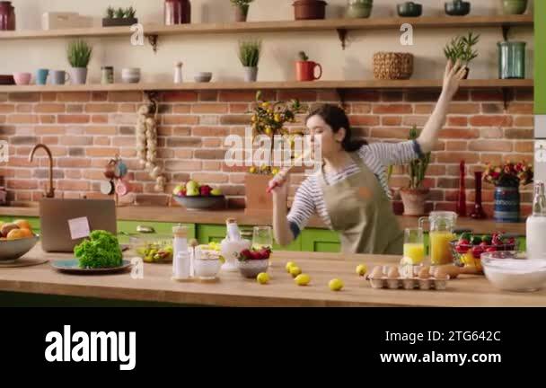 Beautiful and charismatic woman at home at her kitchen island enjoy the ...