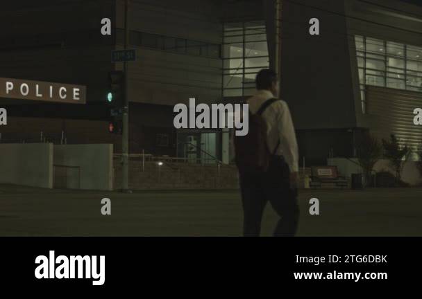A static shot of people walking on the street at night. A police ...