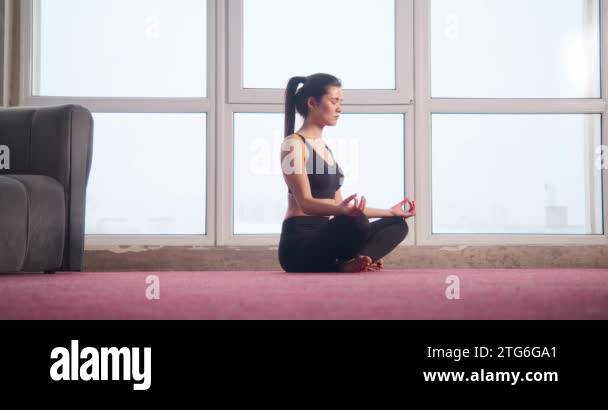 Side view of barefoot girl sitting with crossed legs on red carpet ...