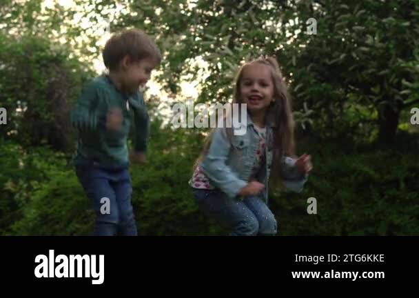 Friends Excited young children siblings Dancing have fun on grass ...