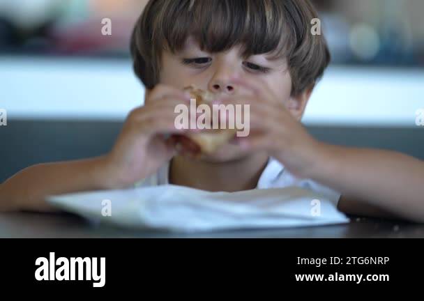 Little boy eating sandwich. Child taking a bite of bread. Kid eats ...
