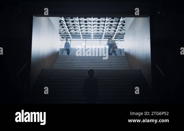 Lonely teen boy going up through children crowd running downstairs ...