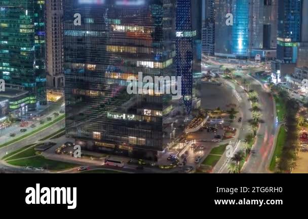 Business Bay Dubai illuminated skyscrapers with traffic on road intersection aerial night ...