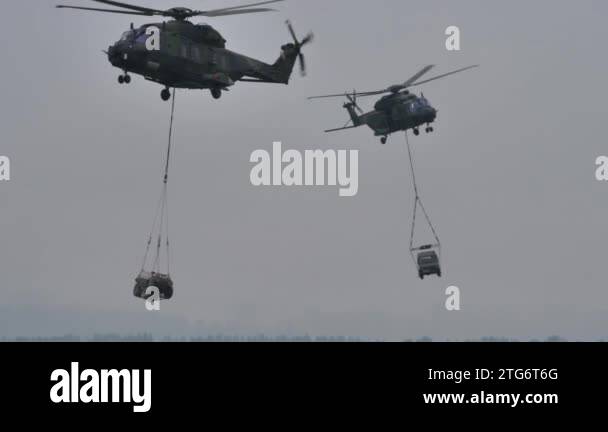Military helicopters in flight with loads hanging underneath. NATO army ...