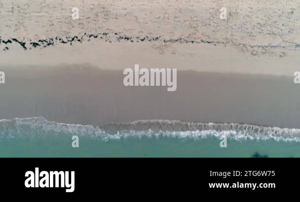 Static top down view of tropical beach, foamy ocean waves washing sand ...