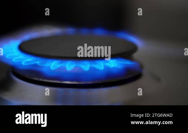 Large hob on stove turning on and burning blue natural gas flames ...