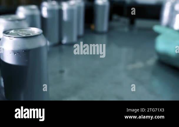 Production brewery worker hands picking up cans on a conveyor belt ...