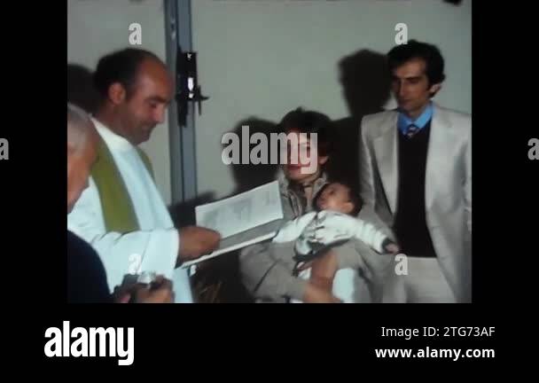 trento , italy april 1970: a priest who celebrates a baptism ceremony ...