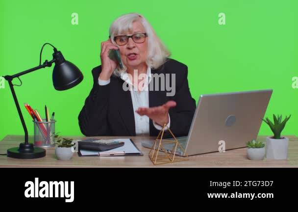 Angry senior old business woman making phone call at office work ...