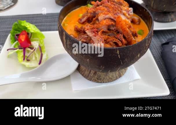 Traditional thai red curry crispy duck dish in a coconut bowl, tasty ...