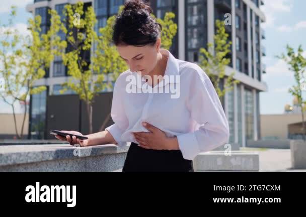 Business woman having stomach ache in street. Female office worker ...