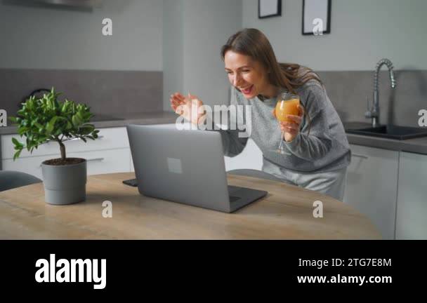 Woman with a glass of orange juice in her hand standing in home cozy ...