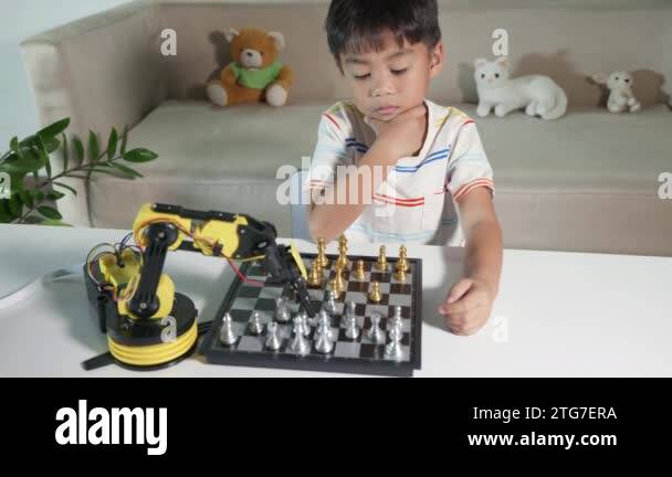 Asian little boy thinking and wait robot arm playing chess, STEM ...