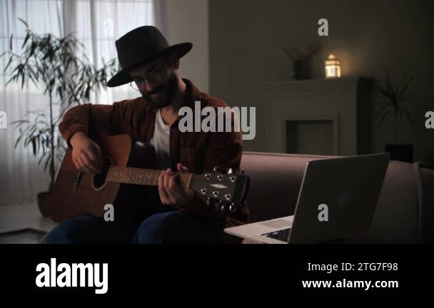 Male guitarist play song online learning using laptop.Man playing ...